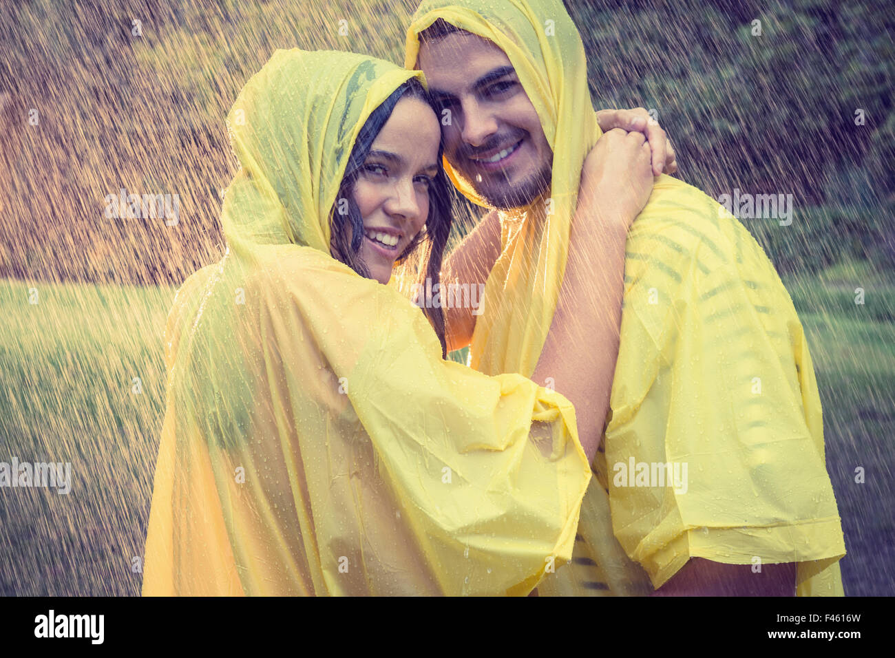 Cute couple wearing protection cape and hugging under the rain Stock ...