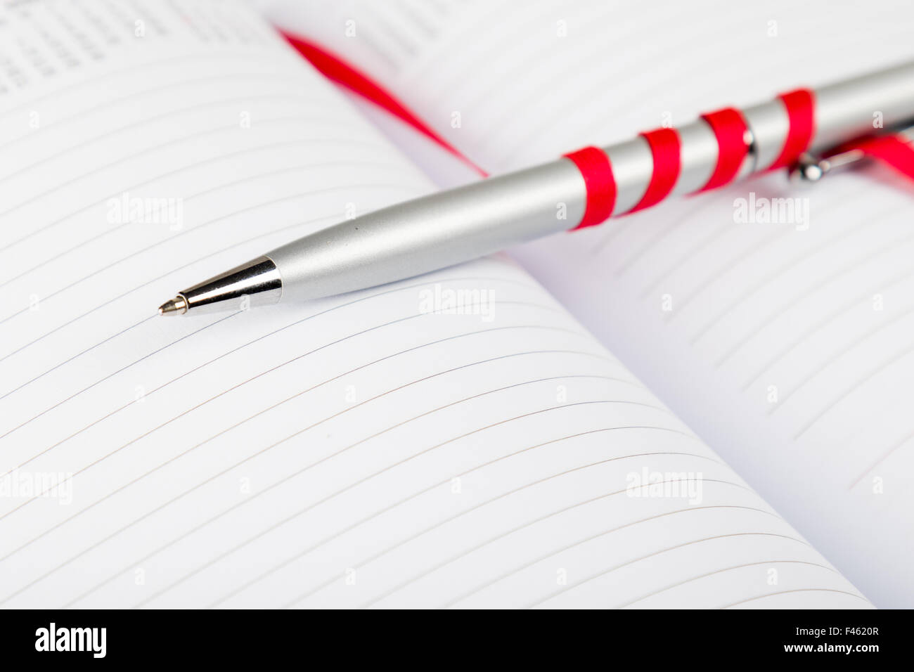 pen on notebook with red string Stock Photo - Alamy