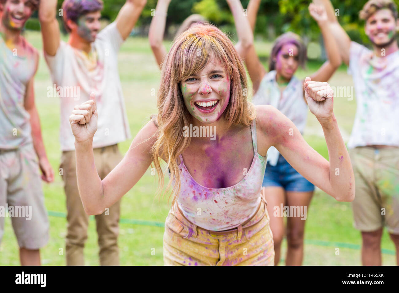 Happy friends throwing powder paint Stock Photo - Alamy