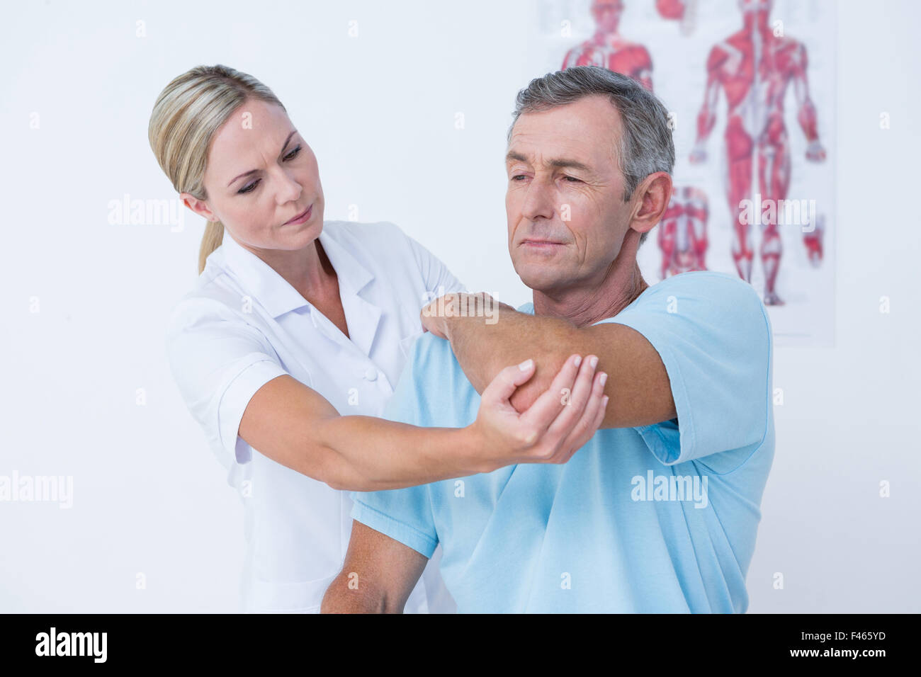 Doctor stretching a man arm Stock Photo - Alamy
