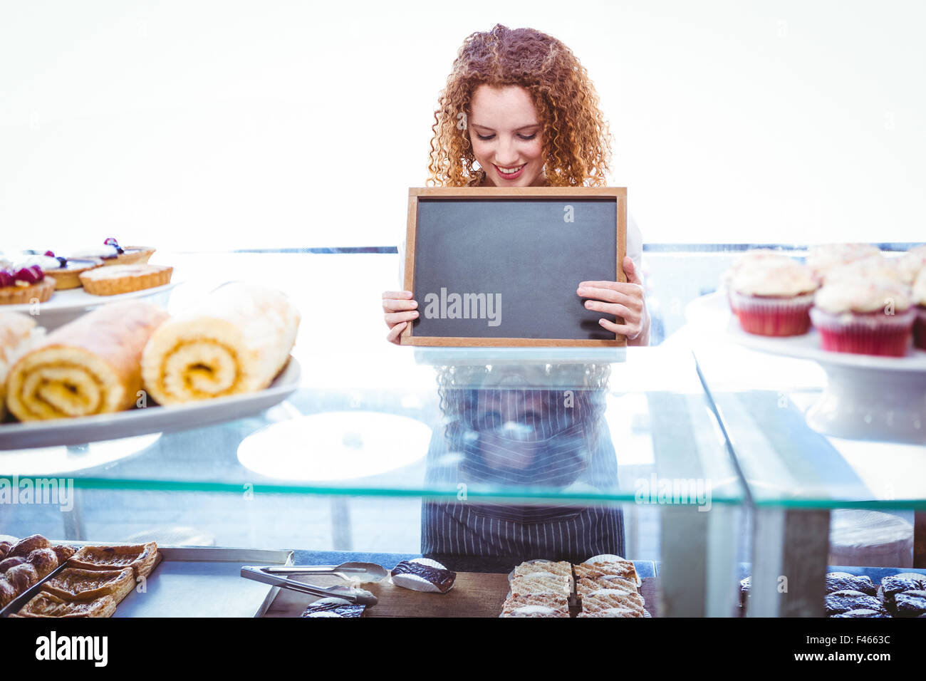 Happy pretty barista holding board Stock Photo - Alamy
