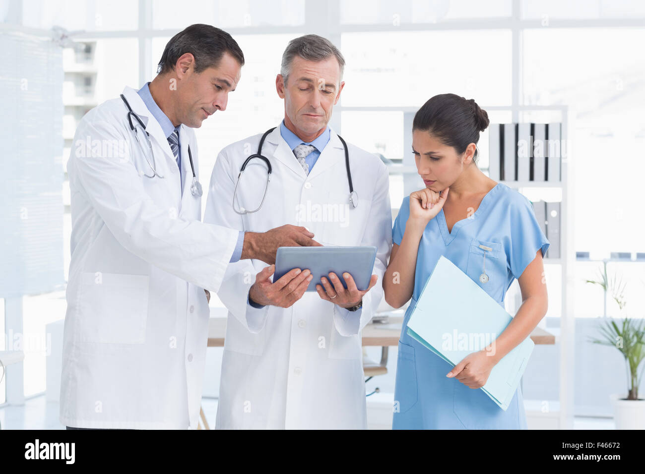 Doctors speaking with nurse Stock Photo - Alamy