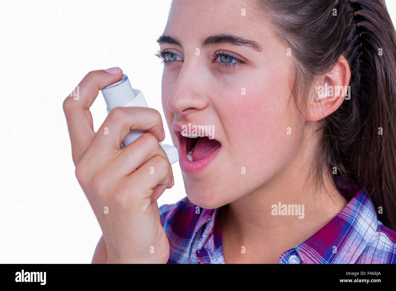 Pretty brunette woman using asthma inhaler Stock Photo - Alamy