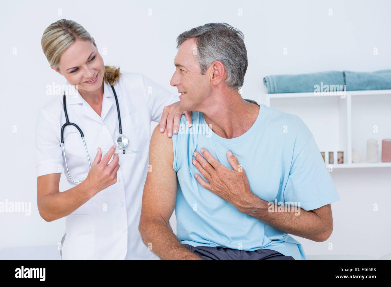 Doctor doing an injection to her patient Stock Photo - Alamy