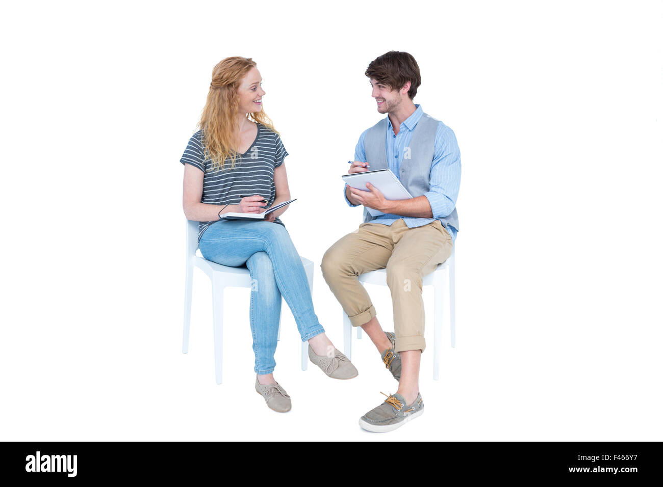 Happy couple speaking and taking notes Stock Photo - Alamy