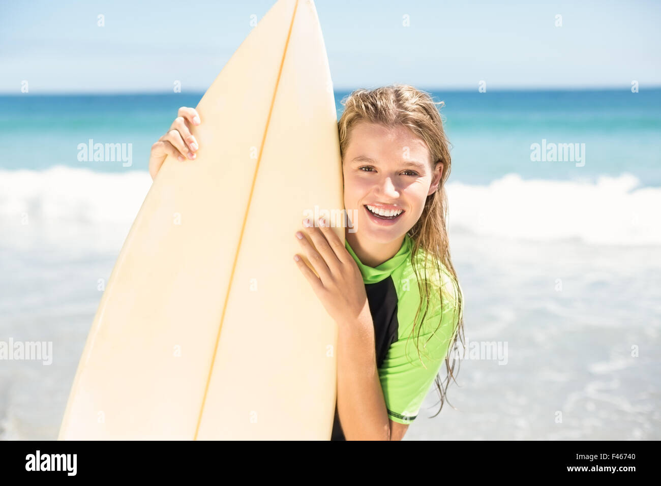 Pretty blonde woman holding surf board Stock Photo - Alamy