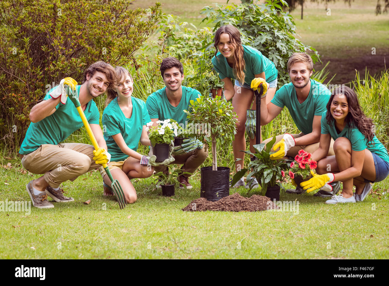 Happy friends gardening for the community Stock Photo - Alamy