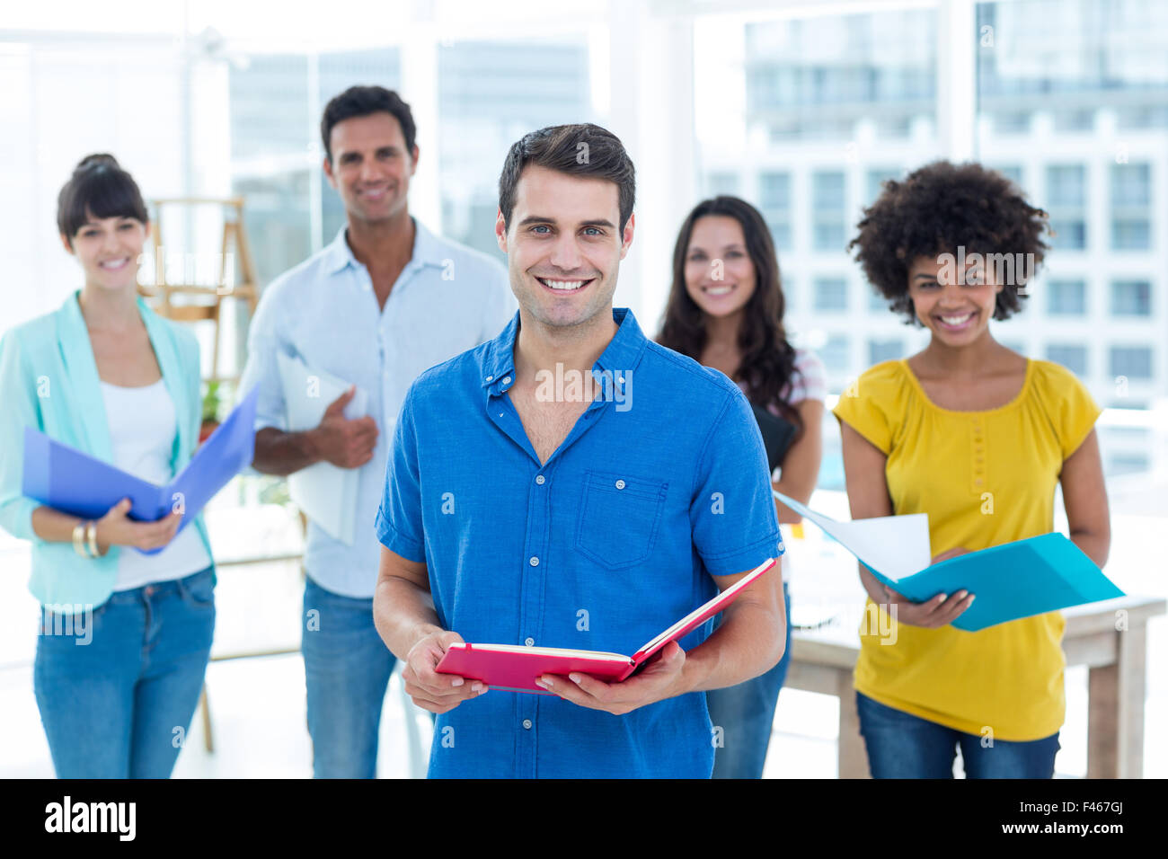 Creative business people holding files Stock Photo - Alamy
