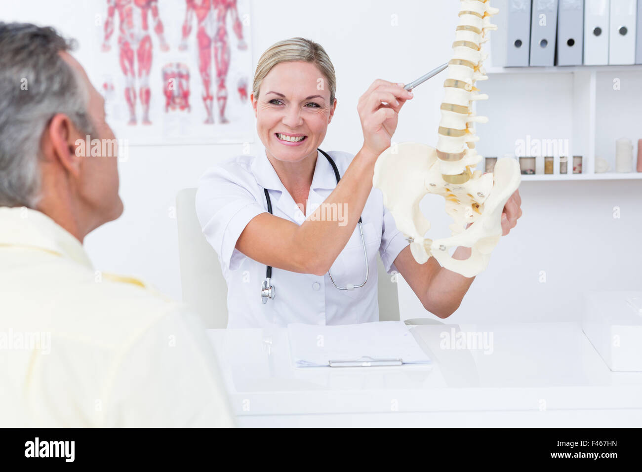 Doctor showing her patient a spine model Stock Photo - Alamy