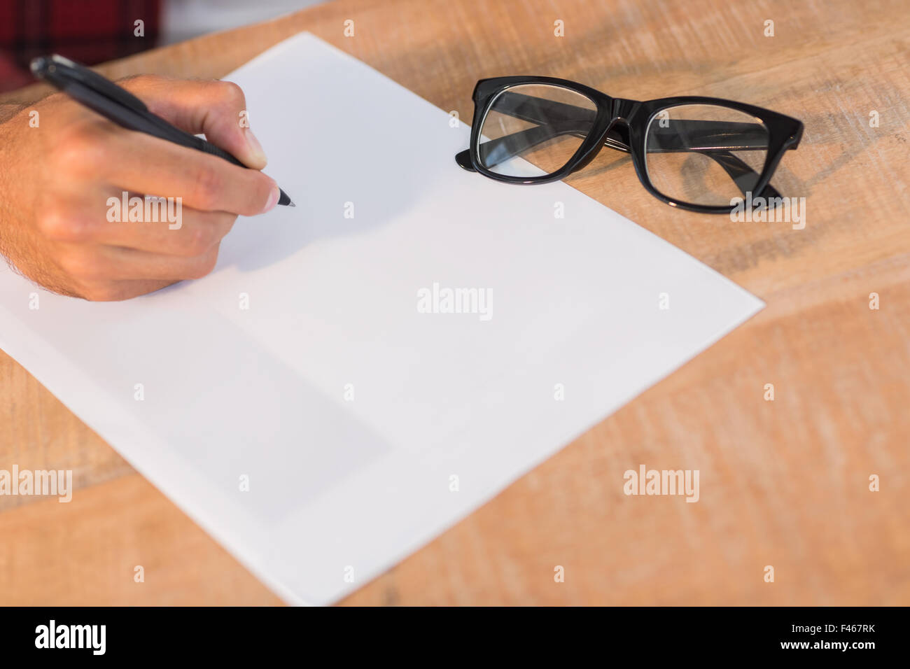 Right hand writing on white page on working desk Stock Photo - Alamy