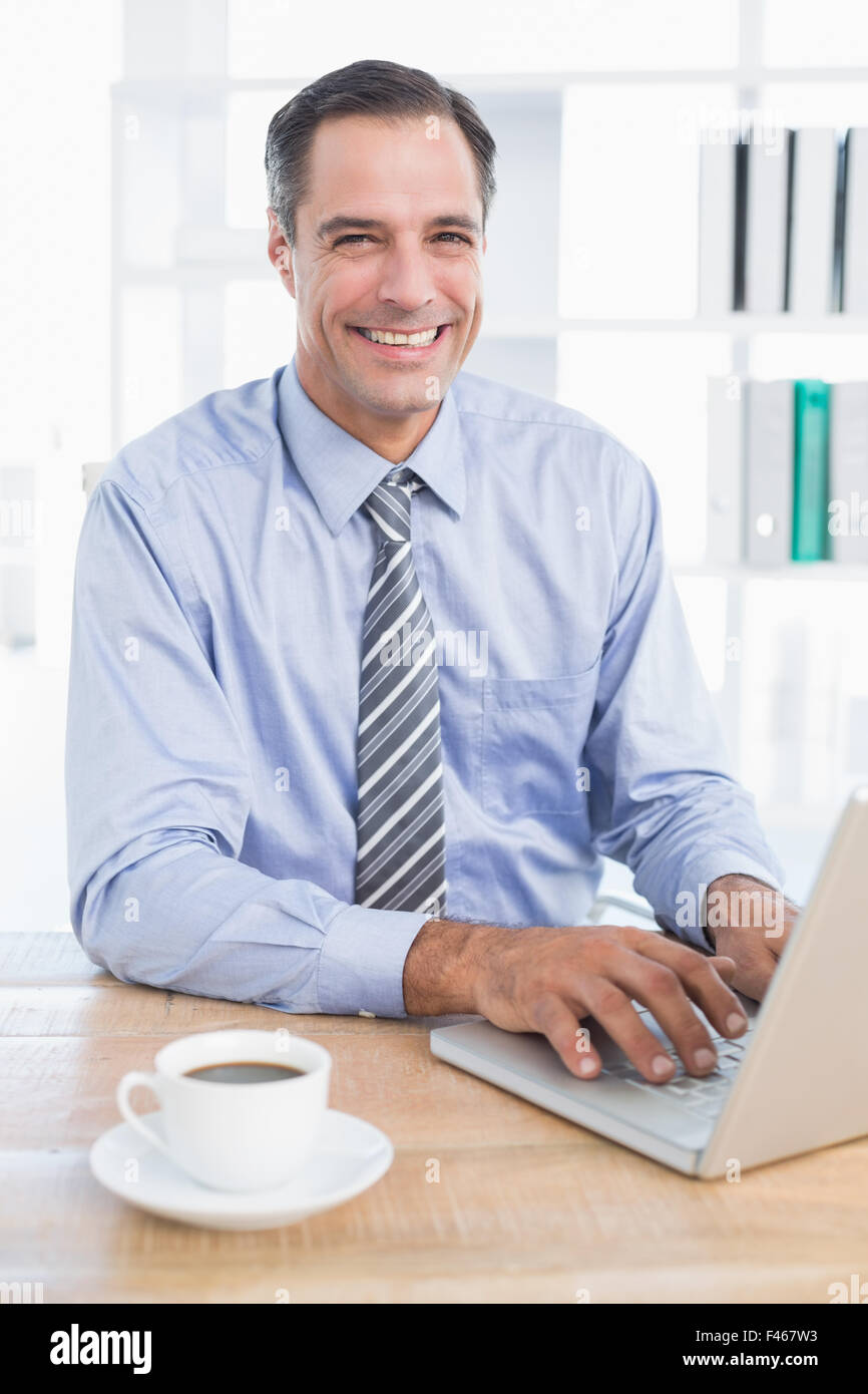 Smiling businessman using his computer Stock Photo - Alamy
