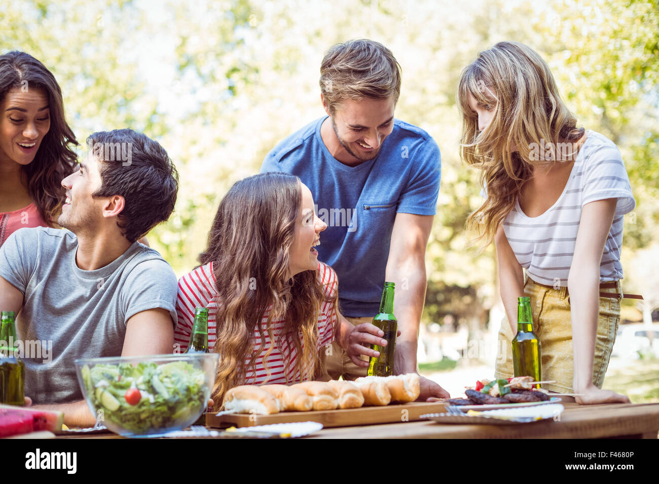Happy friends in the park having lunch Stock Photo - Alamy