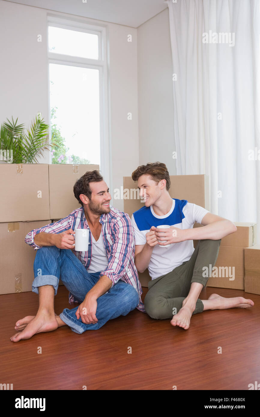 Happy homosexual couple speaking together and holding mug Stock Photo ...