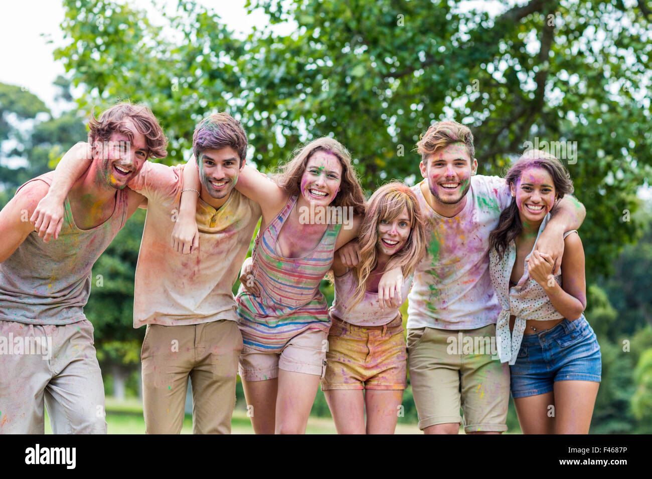 Happy friends covered in powder paint Stock Photo - Alamy