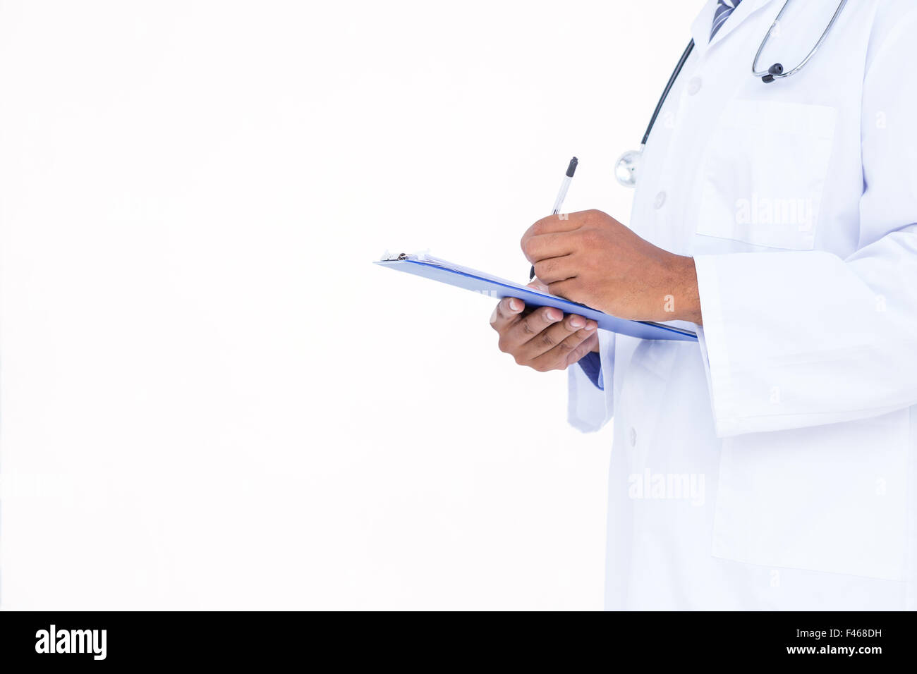Standing doctor in white tunic writing notes Stock Photo - Alamy