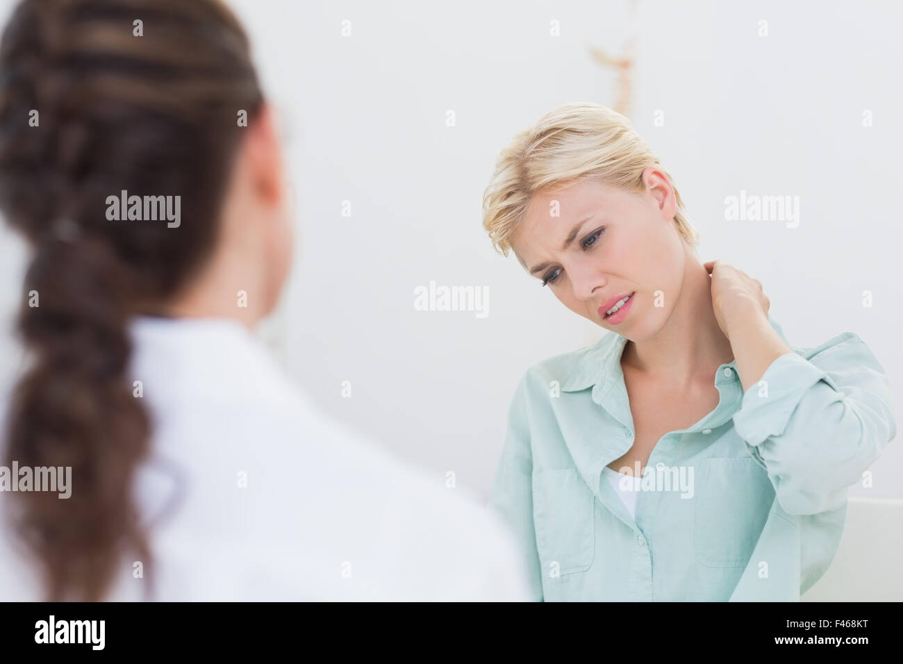 patient with neck pain visiting doctor Stock Photo - Alamy