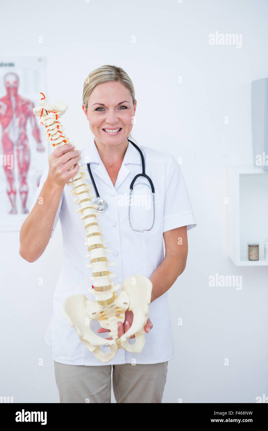 Smiling doctor showing anatomical spine Stock Photo - Alamy