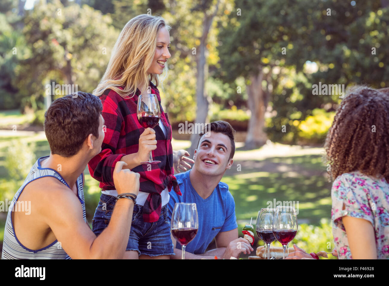 Happy friends in the park having lunch Stock Photo - Alamy