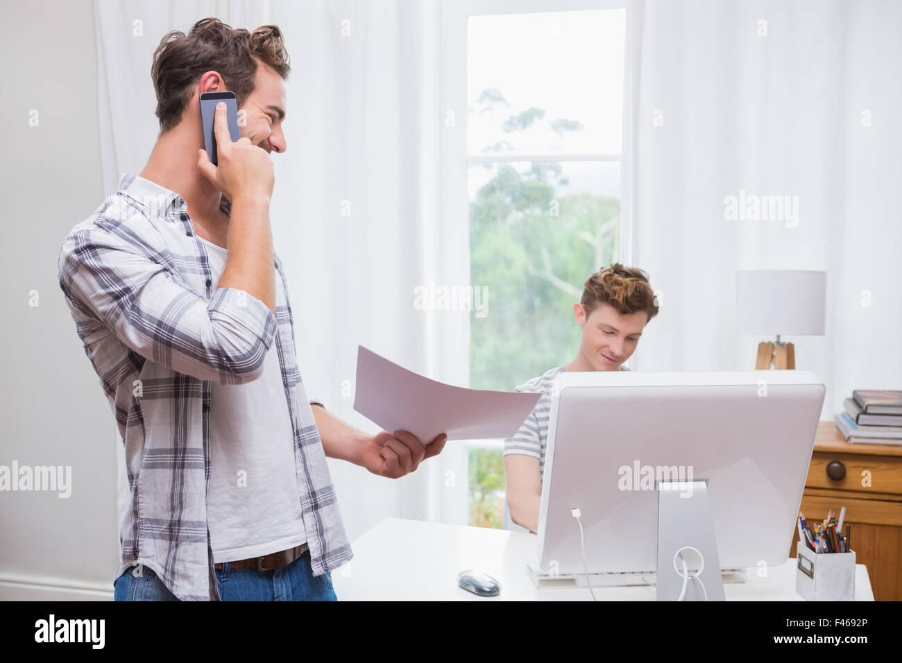 Man having phone call while his boyfriend working on computer Stock ...