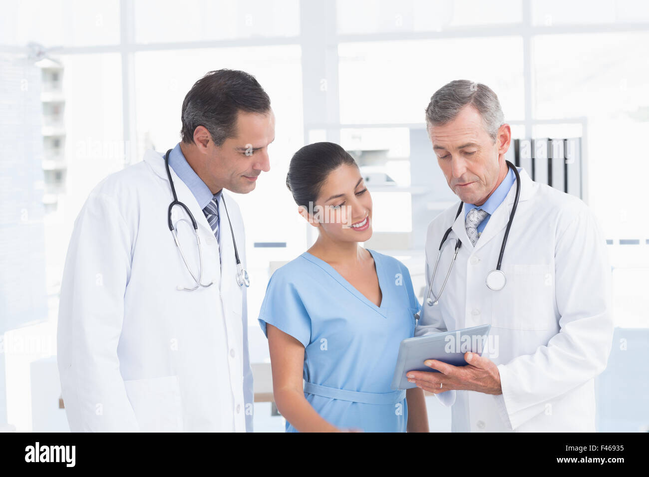 Doctors speaking with nurse Stock Photo - Alamy
