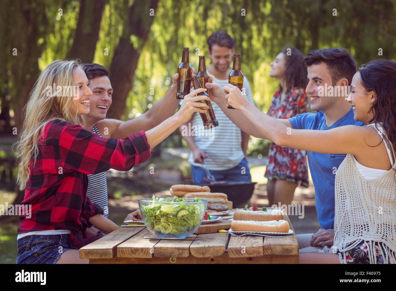 Happy friends in the park having lunch Stock Photo - Alamy