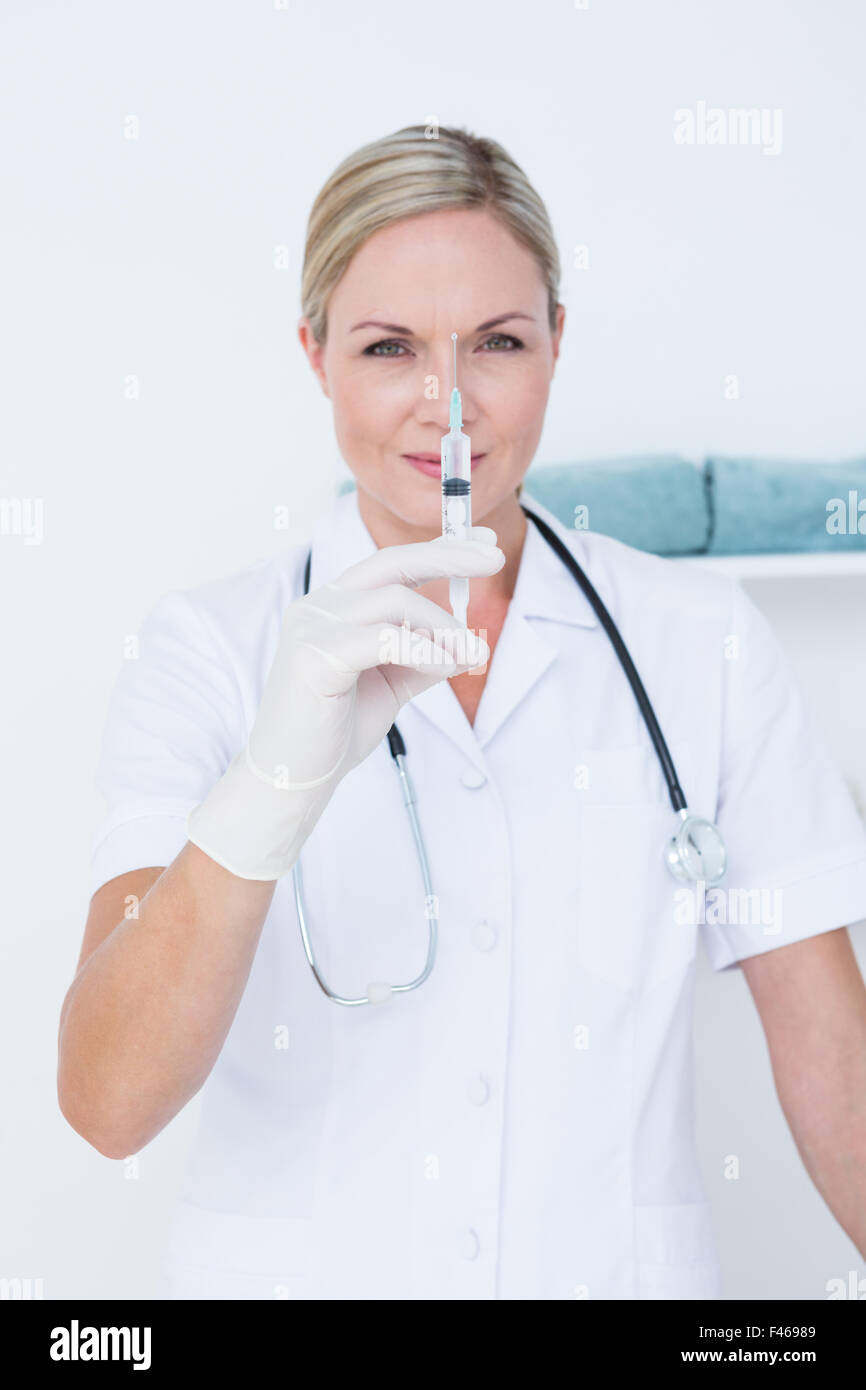 Doctor showing syringe to camera Stock Photo - Alamy