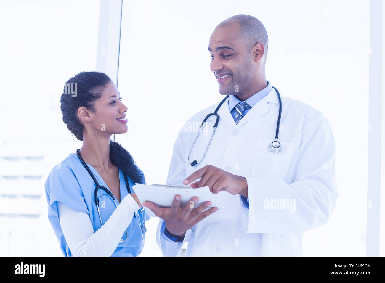 Smiling doctors reading files Stock Photo - Alamy
