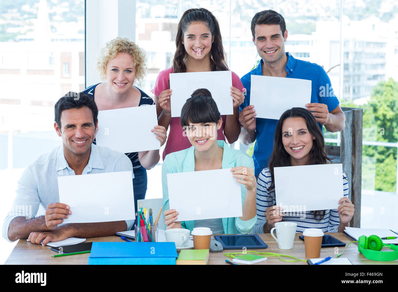 Creative business team holding a signboard Stock Photo - Alamy