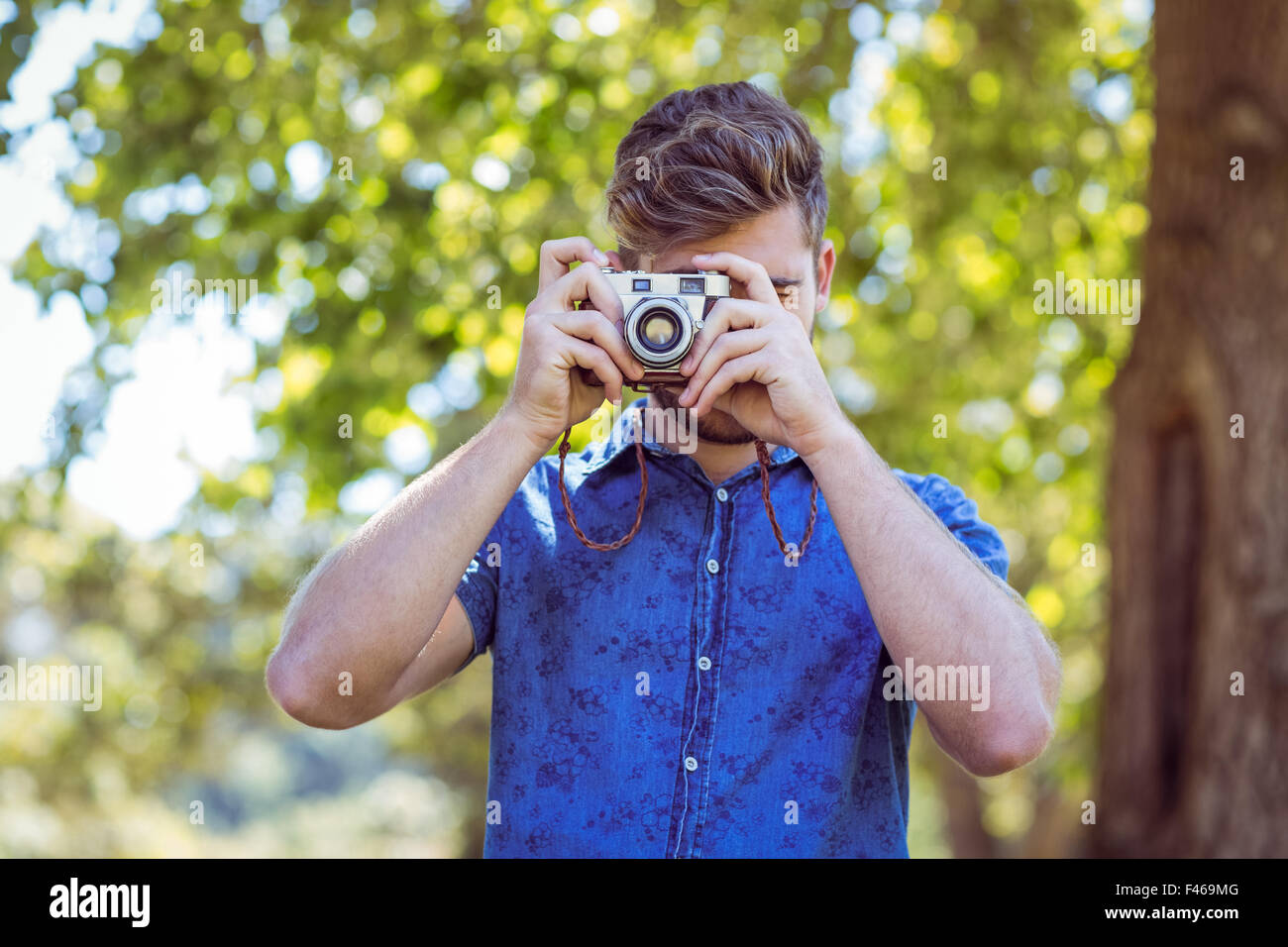 Handsome hipster holding vintage camera Stock Photo - Alamy