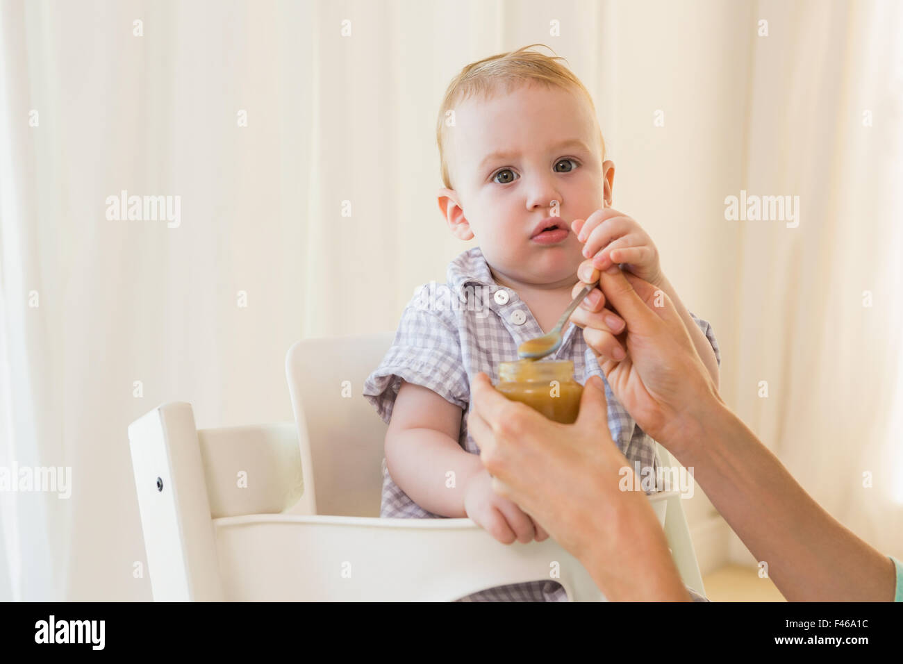 Happy mother eating with her baby boy Stock Photo - Alamy