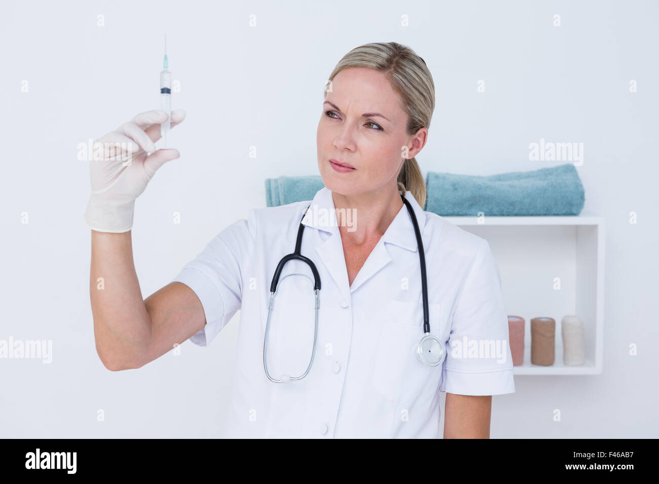 Doctor showing syringe to camera Stock Photo - Alamy