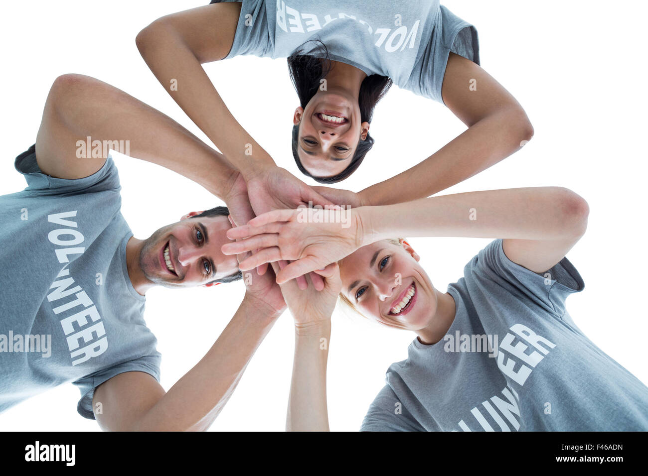Happy volunteers putting their hands together Stock Photo - Alamy