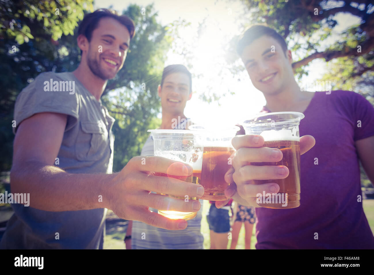 Happy friends in the park having beers Stock Photo - Alamy