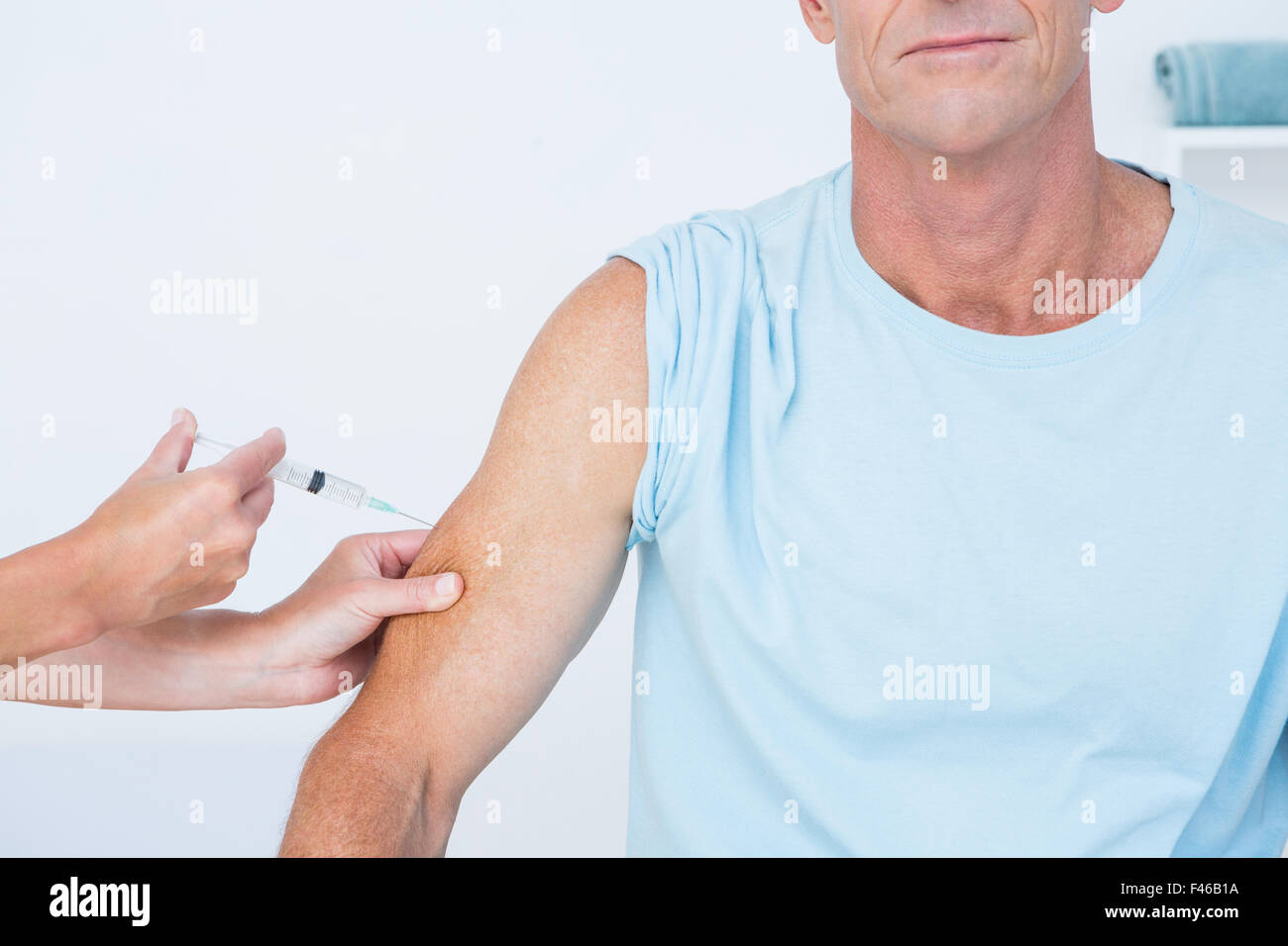 Doctor doing an injection to her patient Stock Photo - Alamy