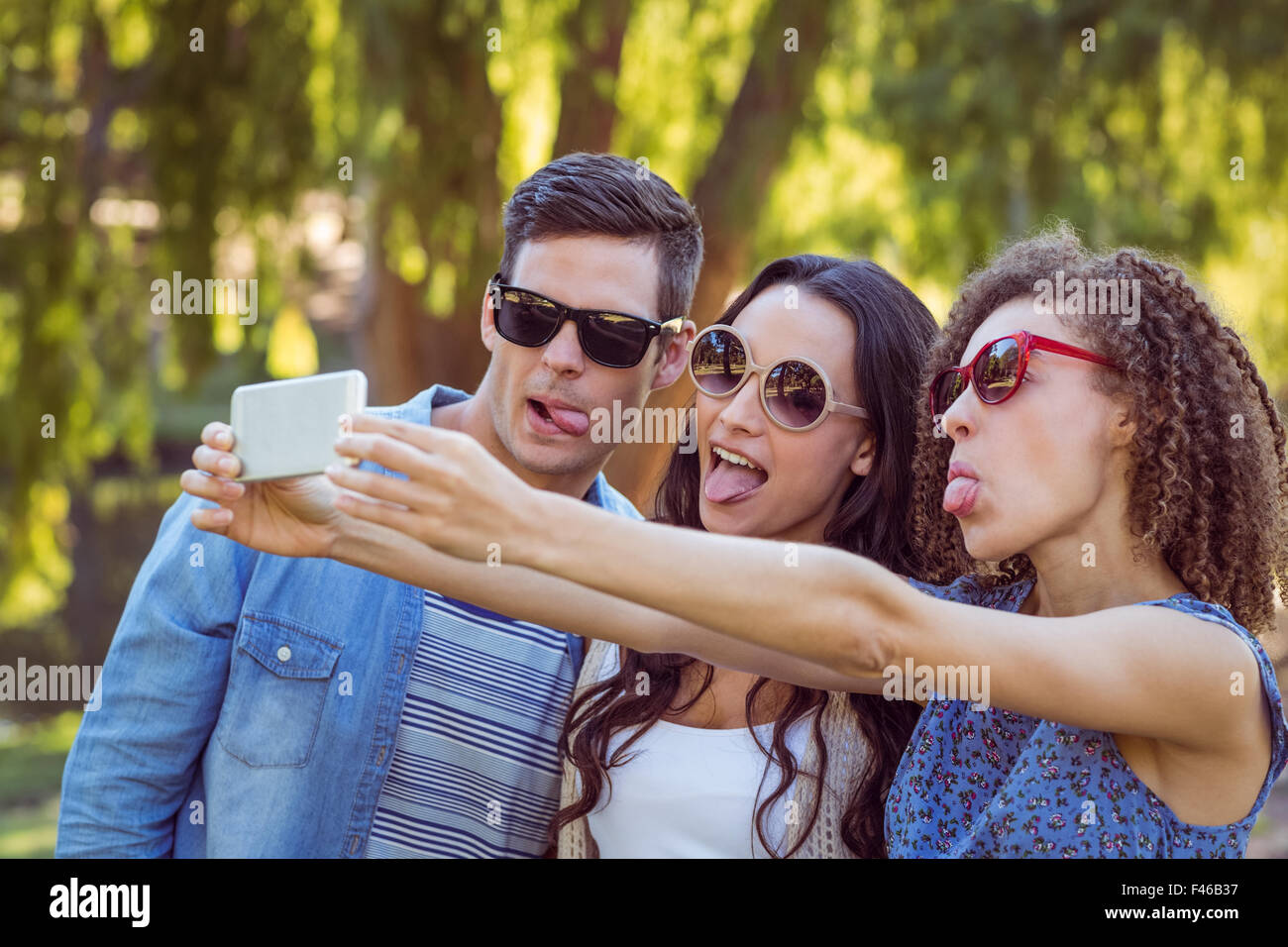 Happy friends taking a selfie in the park Stock Photo - Alamy