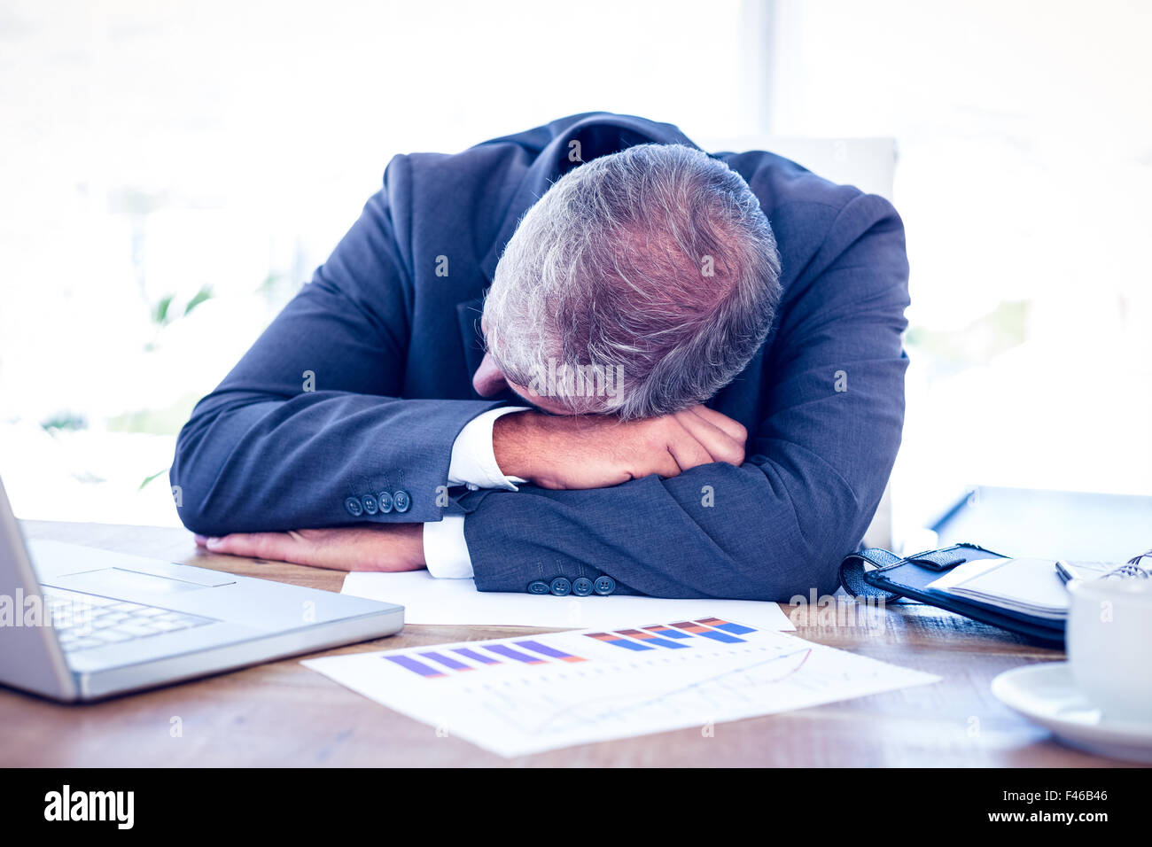 Businessman resting head on desk Stock Photo - Alamy