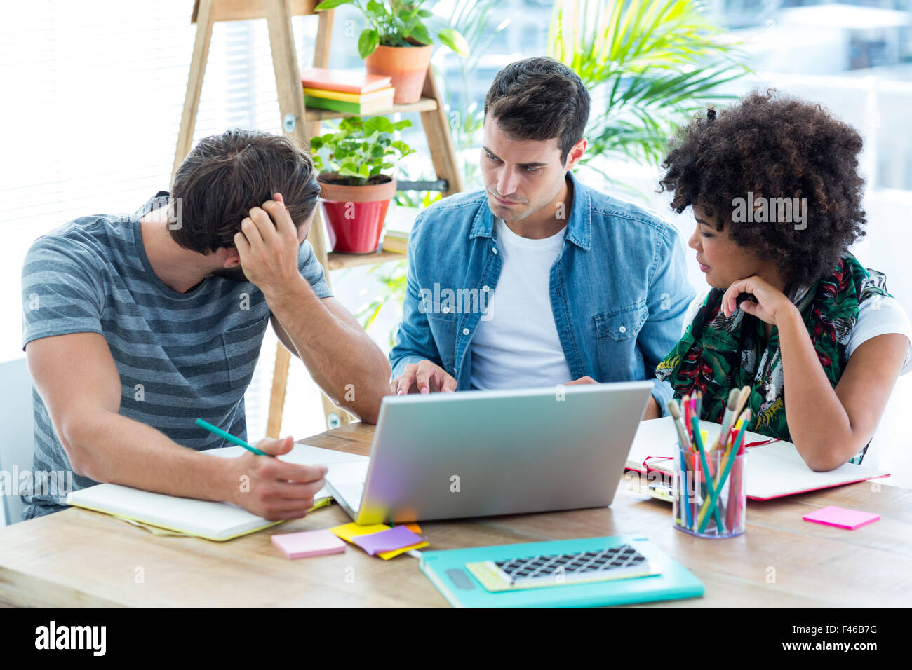 Colleagues using laptop in office Stock Photo - Alamy