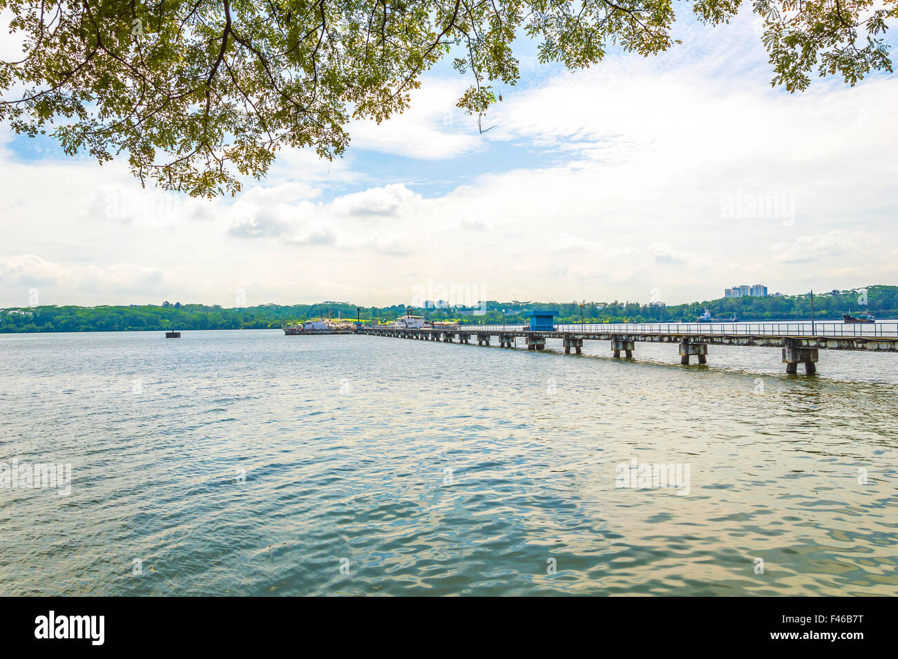Jetty to port harbor with cloudy skies Stock Photo - Alamy