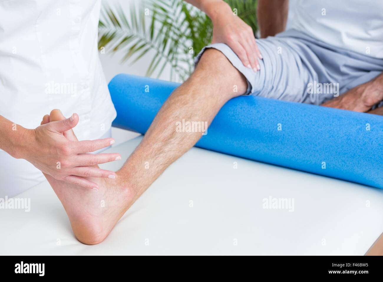 Doctor examining her patient leg Stock Photo - Alamy