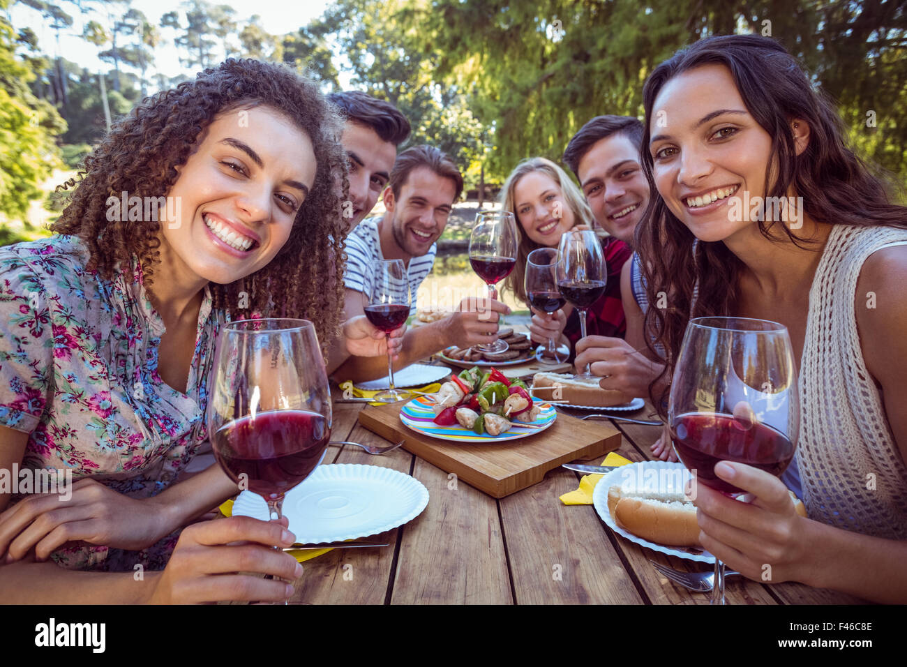 Happy friends in the park having lunch Stock Photo - Alamy