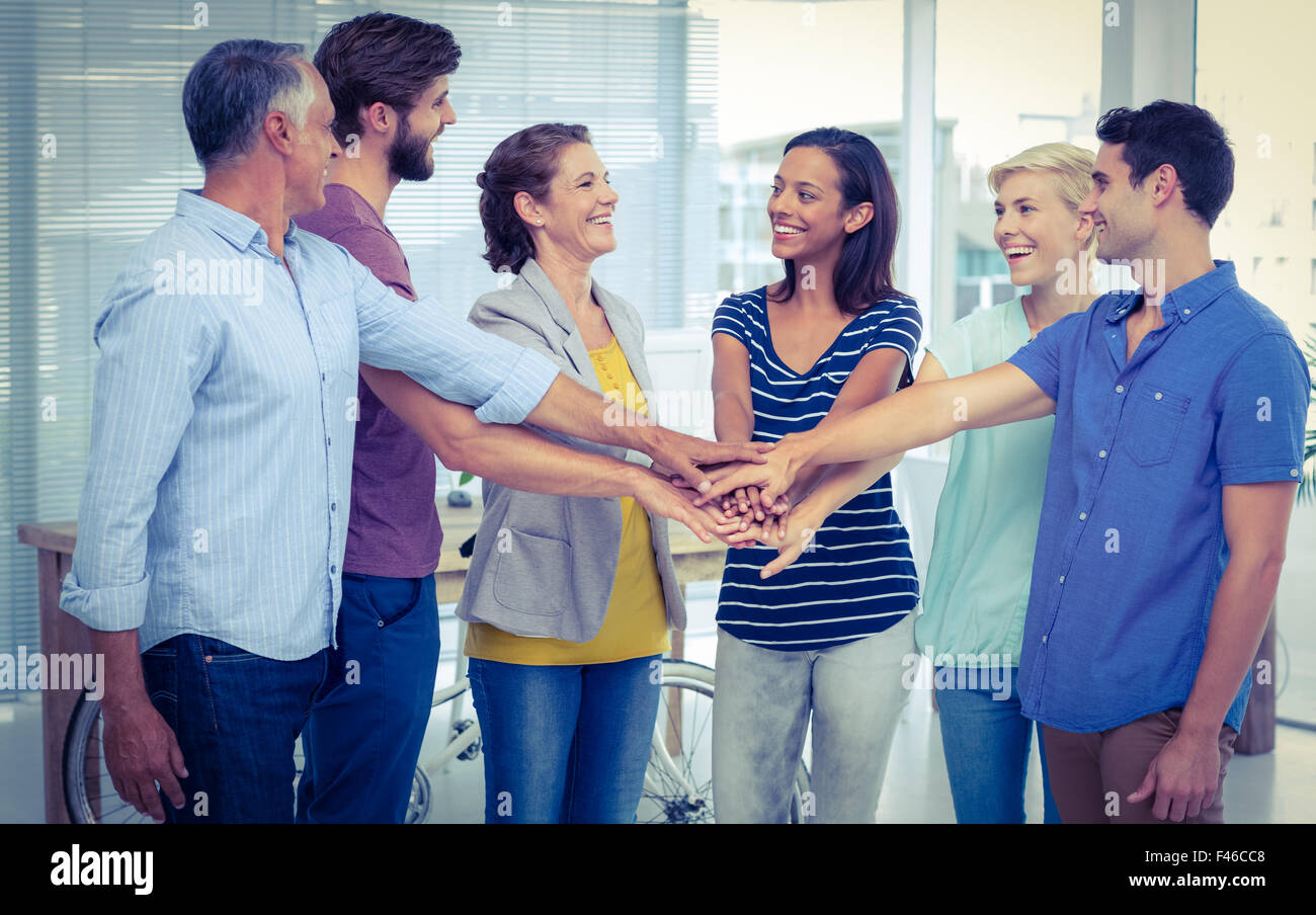 Happy creative team stacking hands hi-res stock photography and images - Alamy