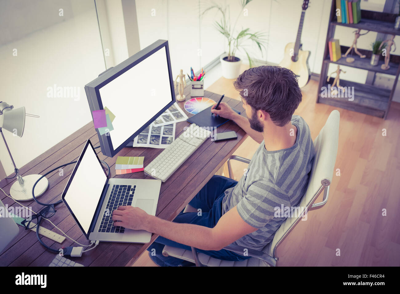 Casual businessman using computers in office Stock Photo - Alamy