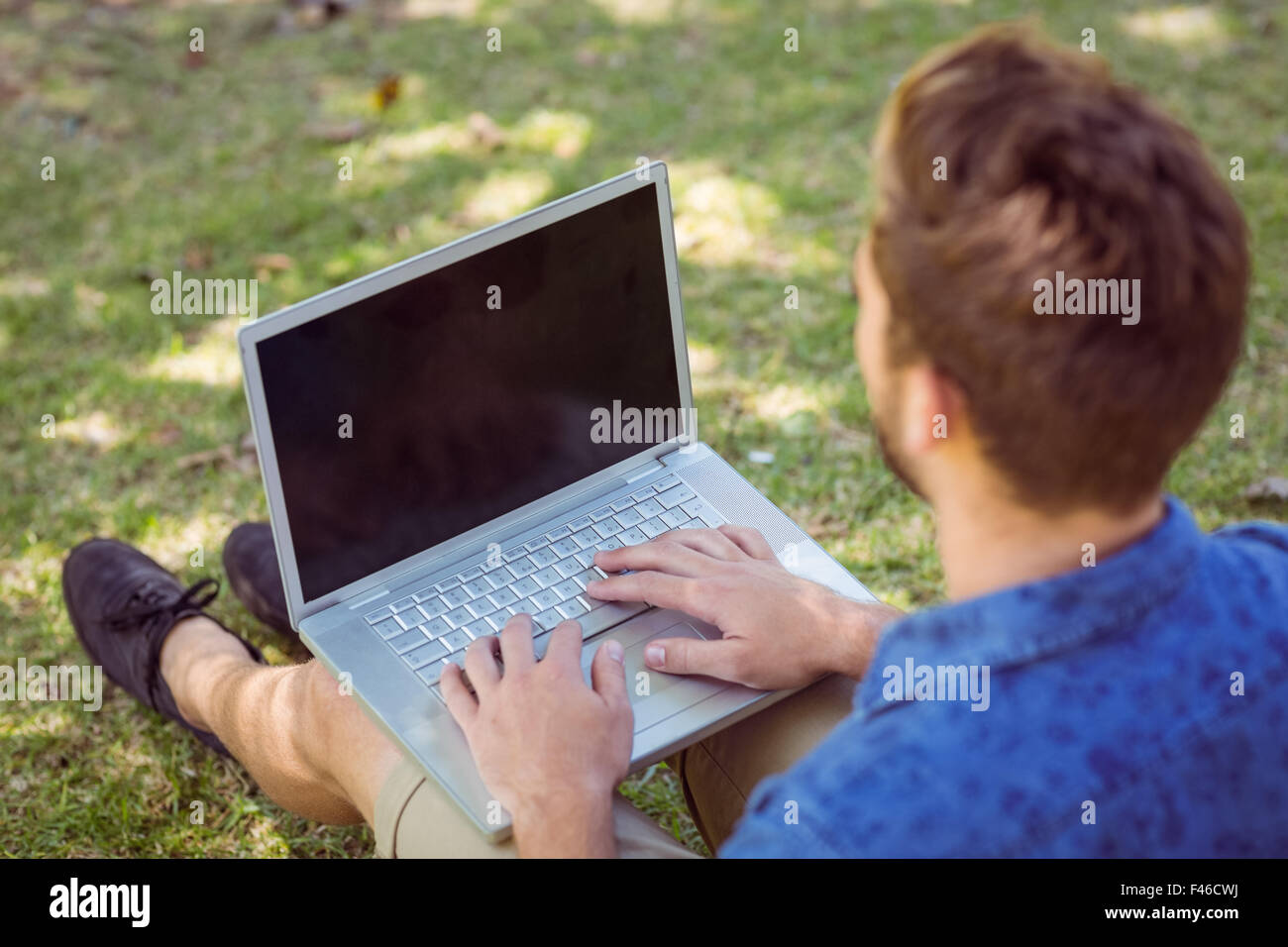 Young man using laptop in the park Stock Photo - Alamy
