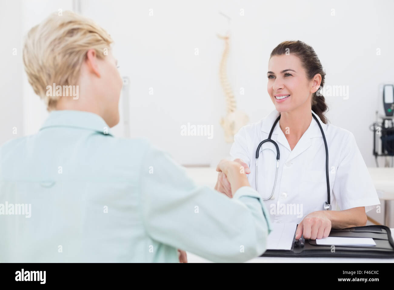 Smiling doctor shaking hand to her patient Stock Photo - Alamy