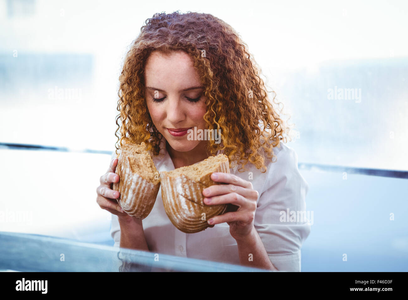 A pretty barista smelling bread Stock Photo - Alamy