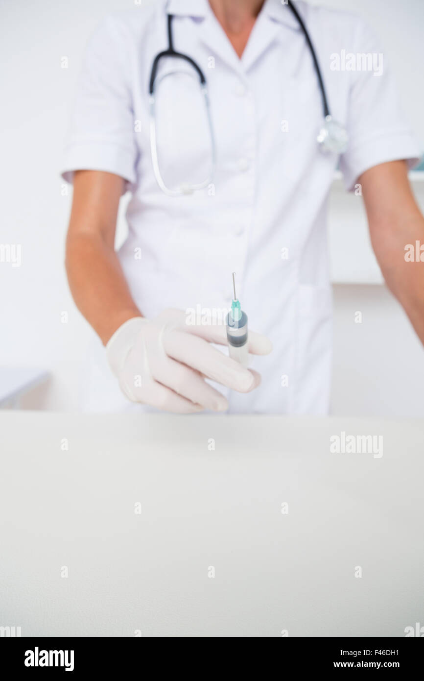 Doctor showing syringe to camera Stock Photo - Alamy