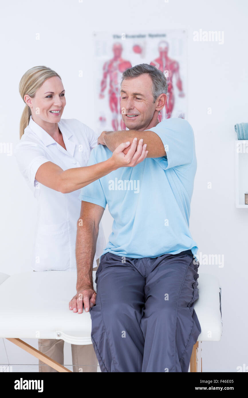 Doctor stretching a man arm Stock Photo - Alamy