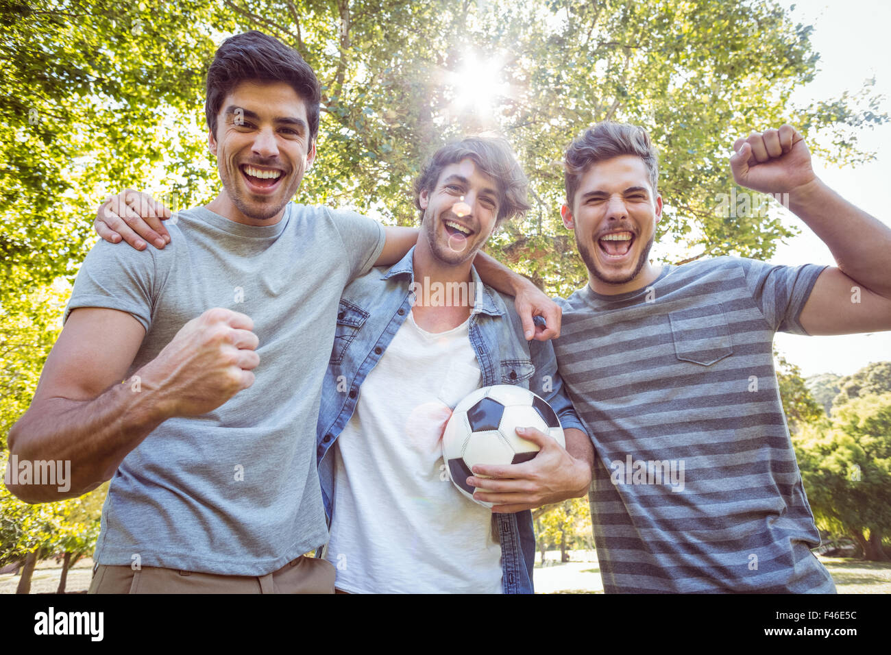 Happy friends in the park with football Stock Photo - Alamy