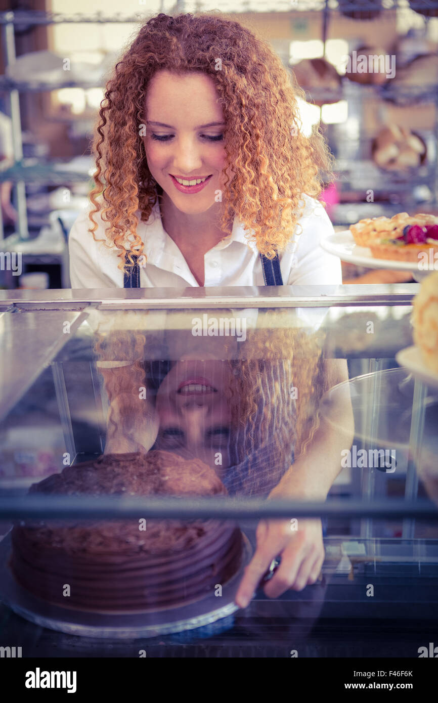 Happy pretty barista putting chocolate cake on counter Stock Photo - Alamy