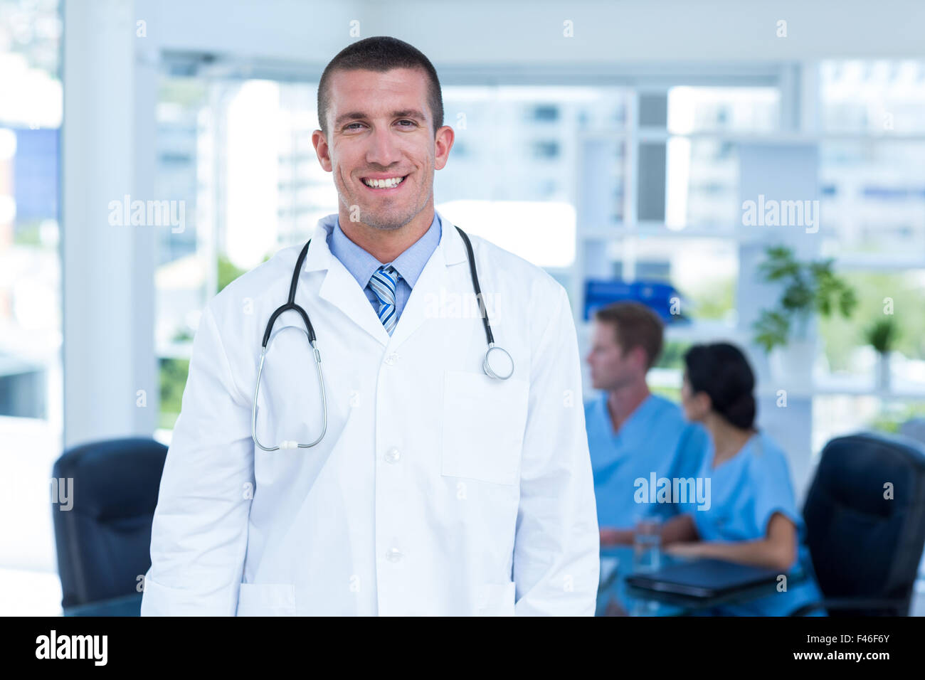 Handsome smiling doctor looking at camera Stock Photo - Alamy